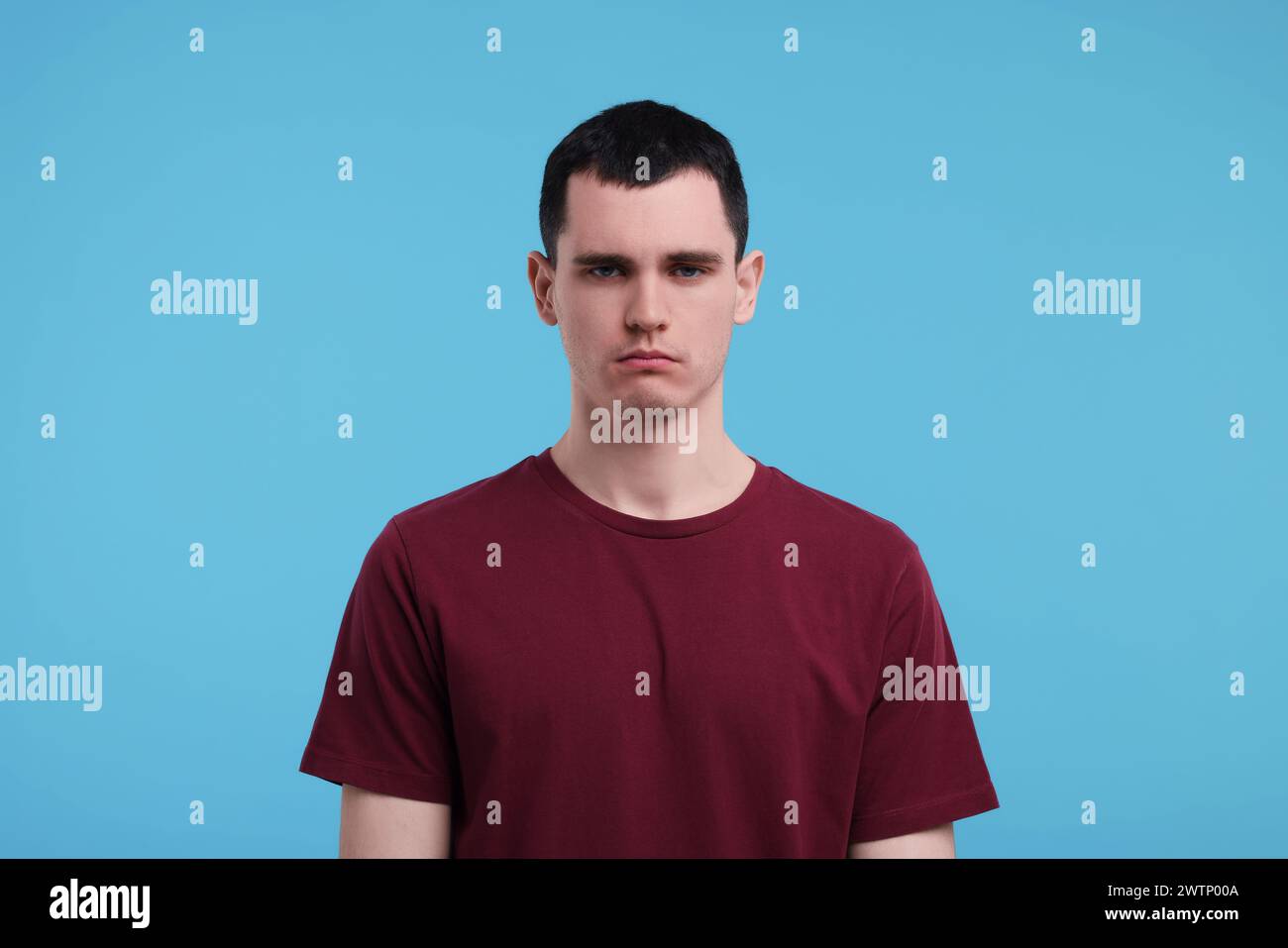 Portrait of sad man on light blue background Stock Photo - Alamy