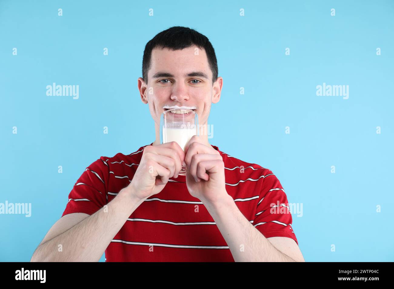 Milk mustache left after dairy product. Man drinking milk on light blue ...