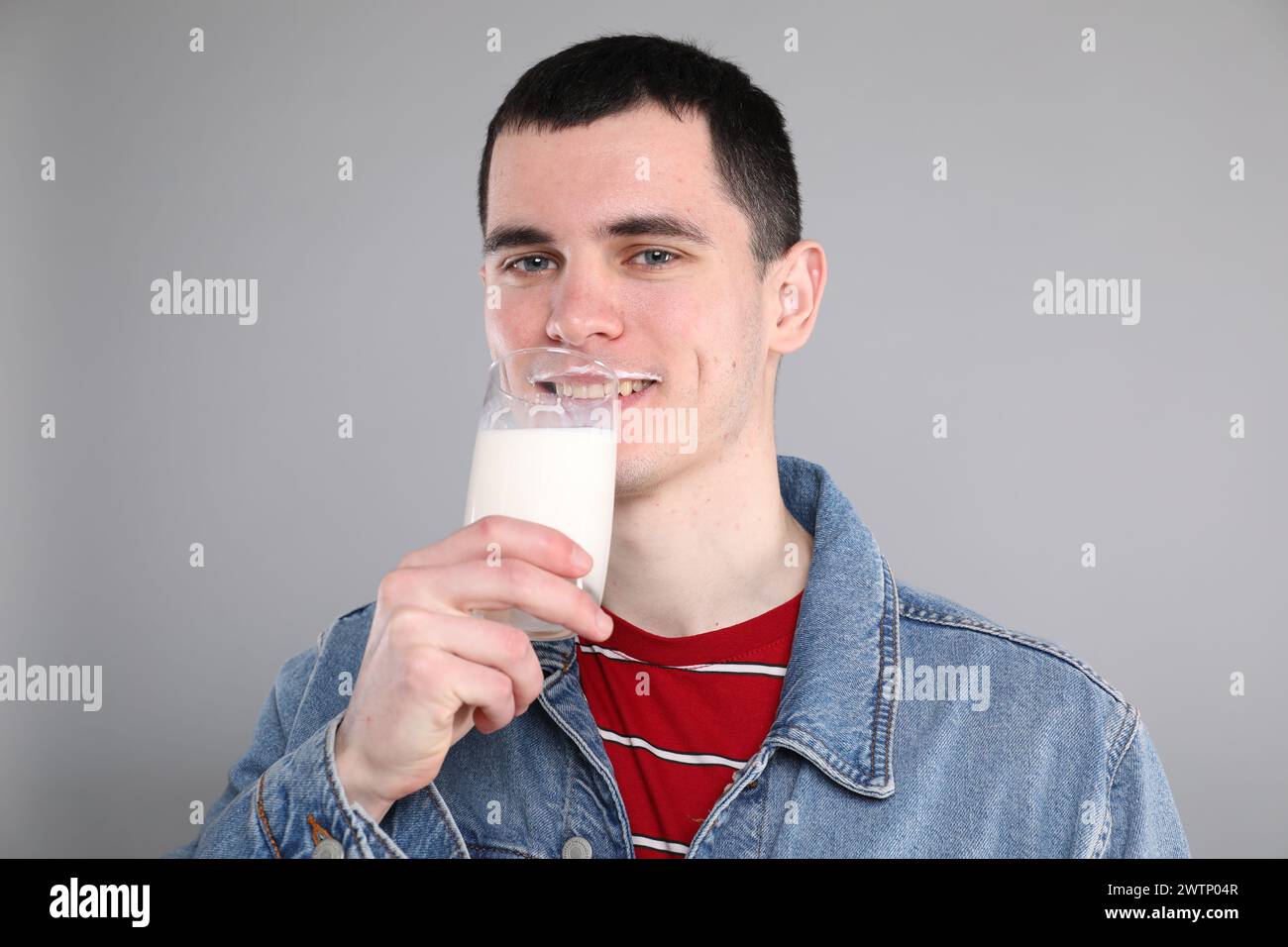 Milk mustache left after dairy product. Man drinking milk on gray ...