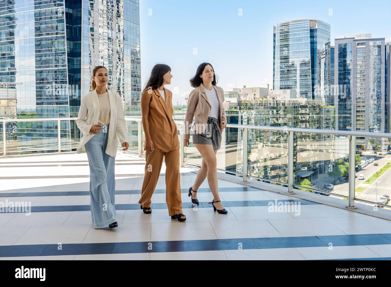 Three succesful businesswomen walking on a tower building terrace Stock ...