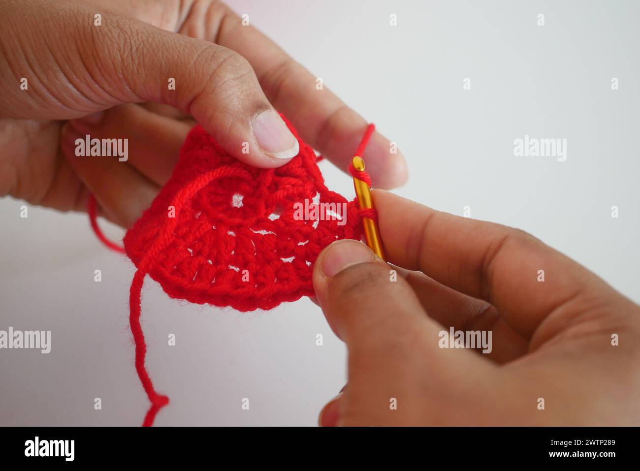 Hand close up crocheting with a pink hook, wool yarn, creative craft ...