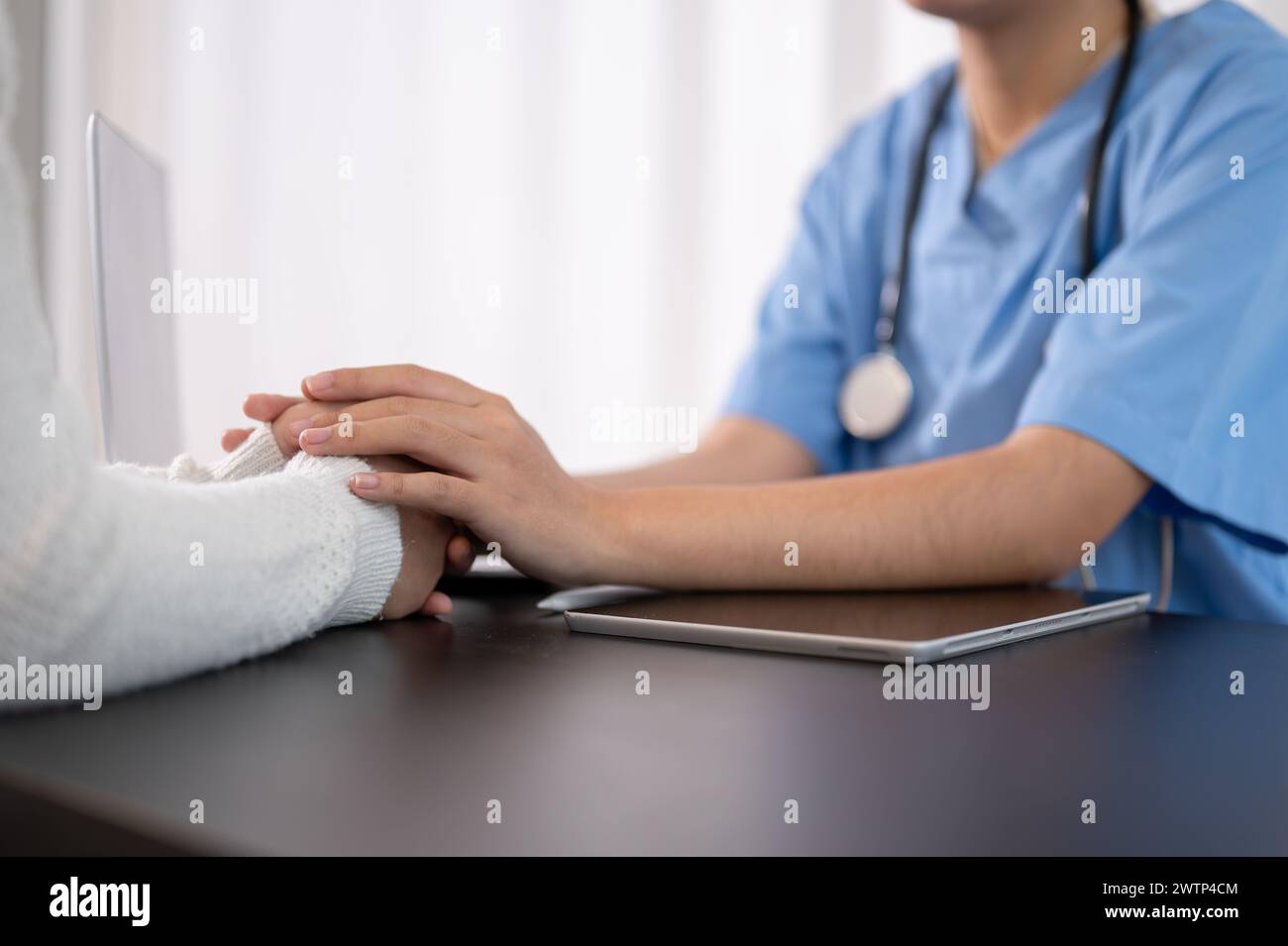 A close-up image of a caring female doctor is touching a female patient ...