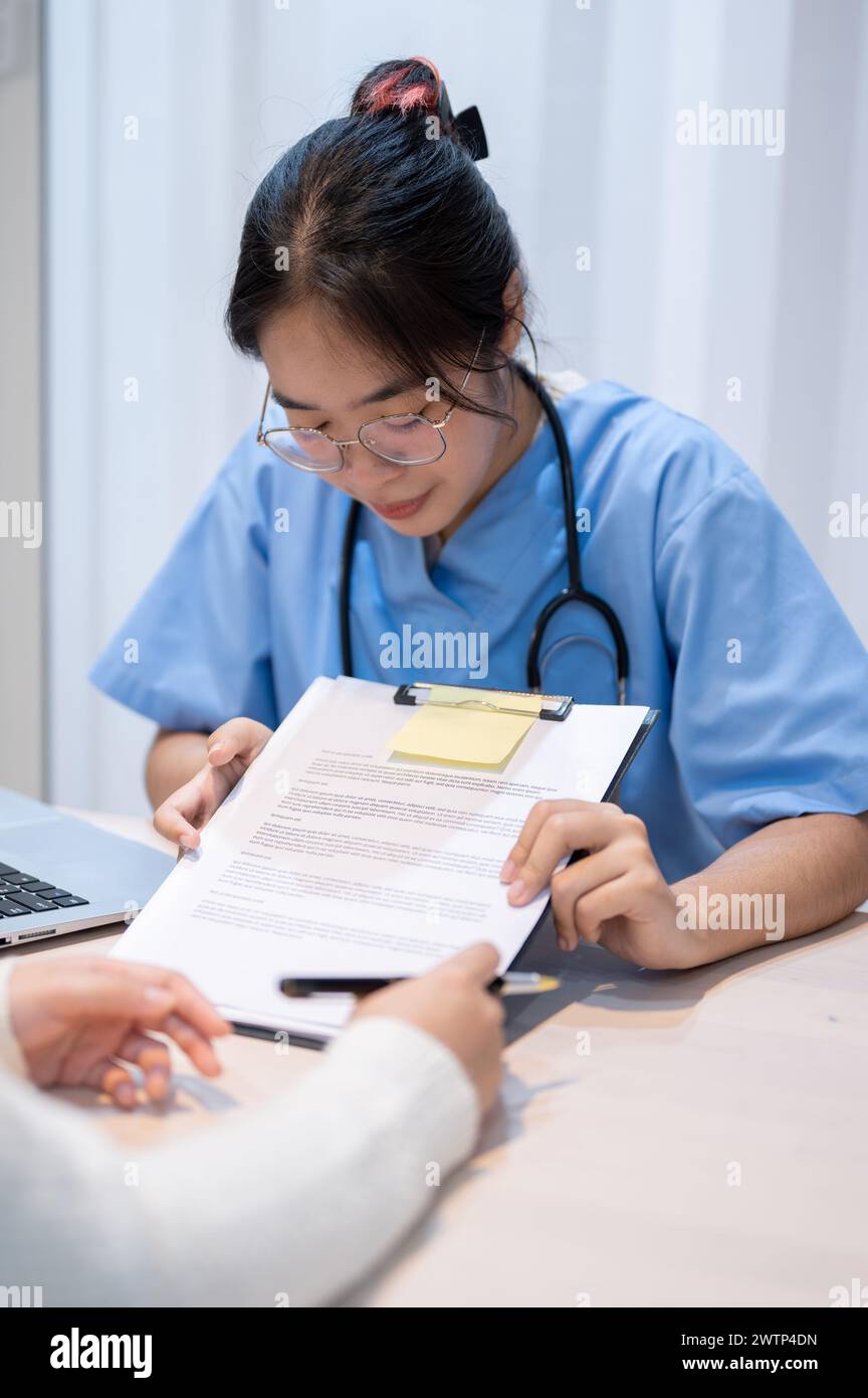 A professional Asian female doctor showing a medical checkup form or ...