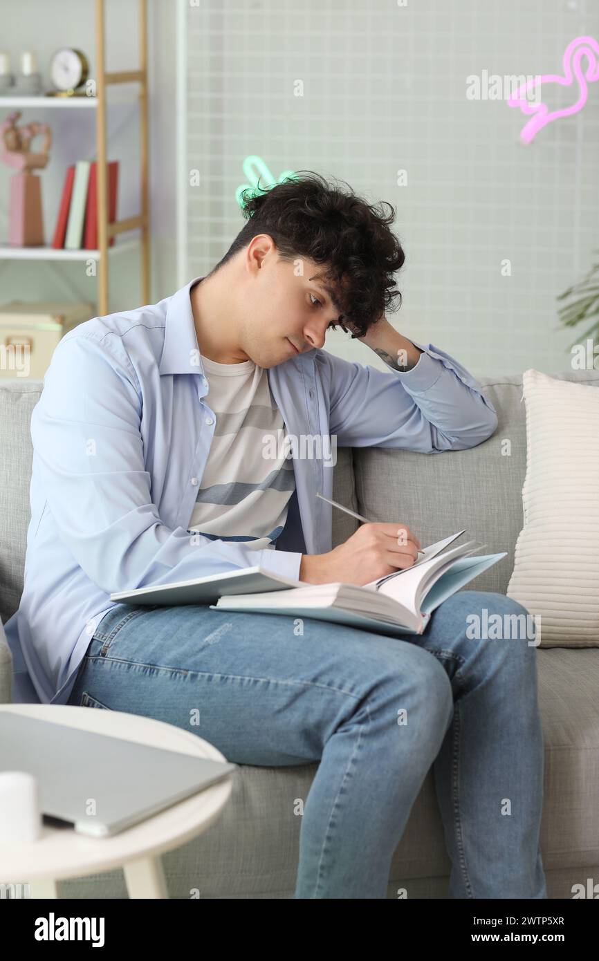 Tired male student studying at home Stock Photo - Alamy