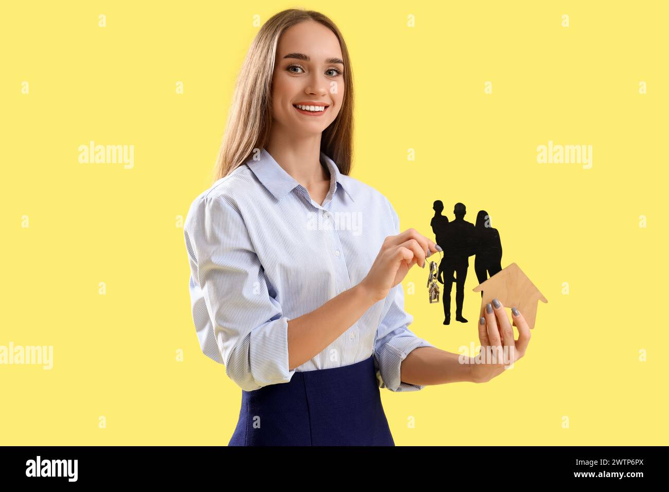 Portrait of female real estate agent with house model and paper human ...