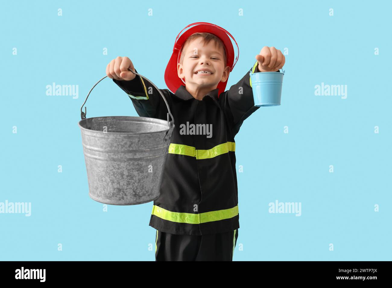 Cute little firefighter with buckets on blue background Stock Photo - Alamy