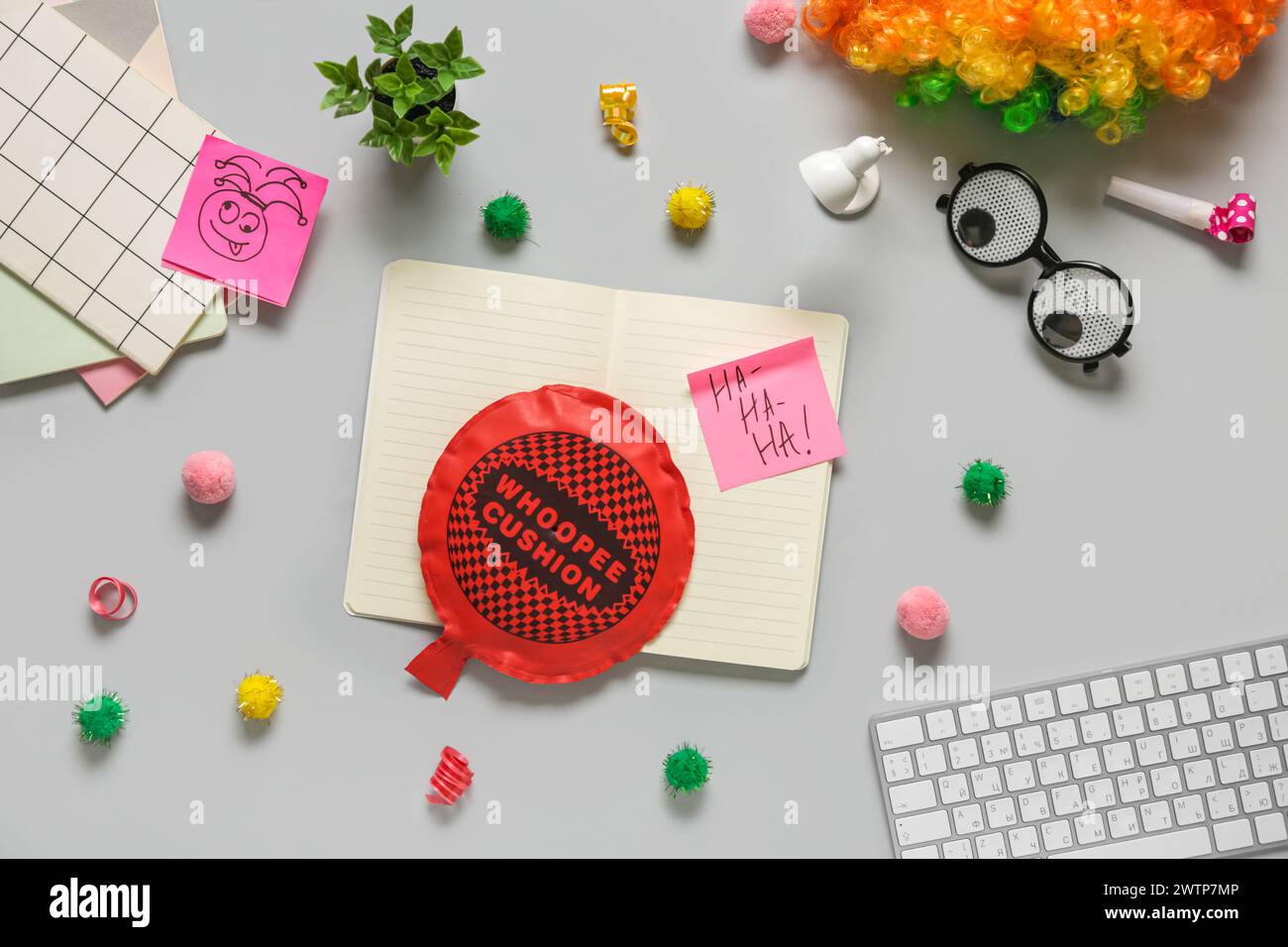 Computer keyboard with whoopee cushion, funny glasses and sticky notes ...