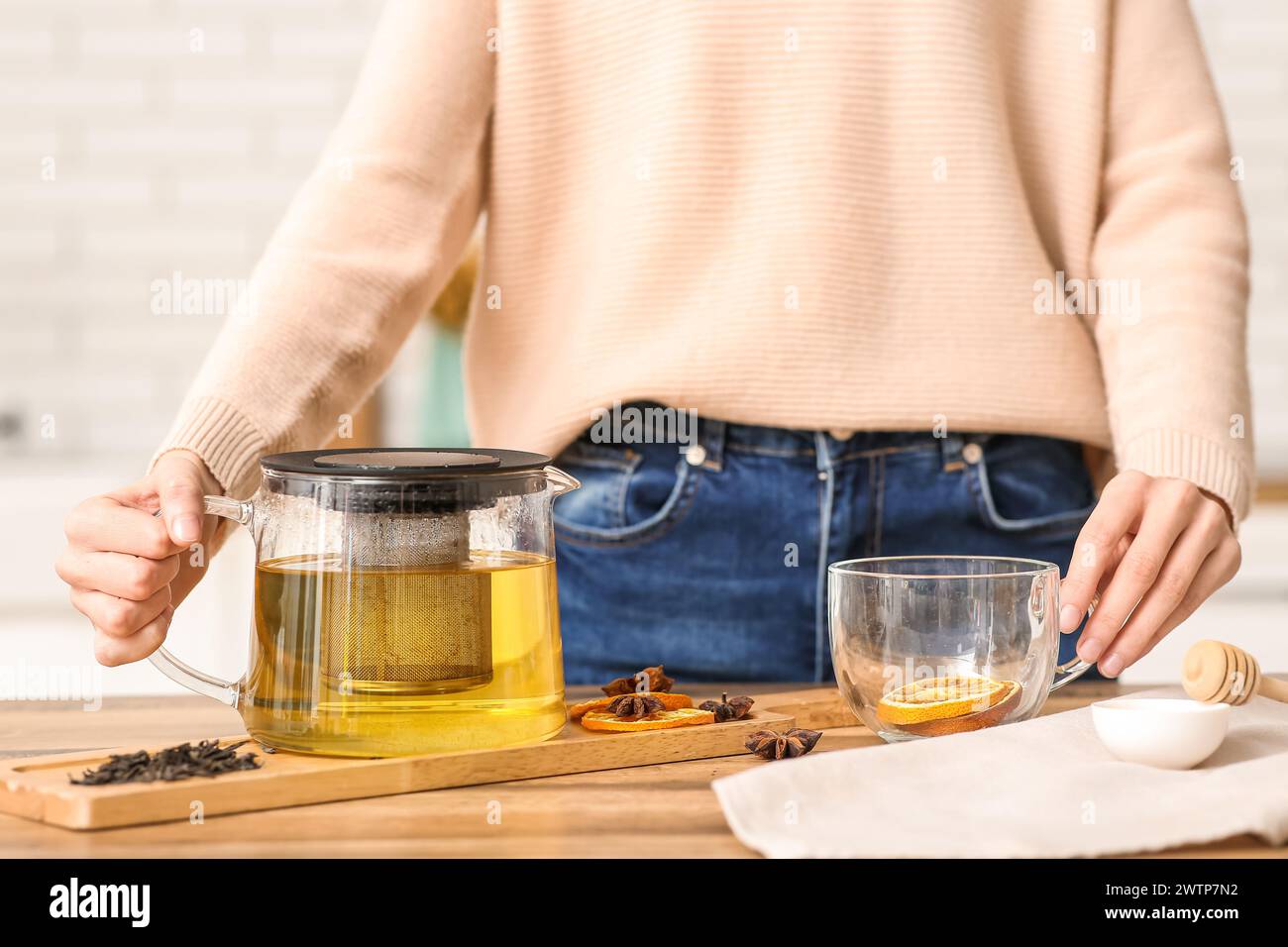 Young woman making green tea with spices in kitchen Stock Photo - Alamy