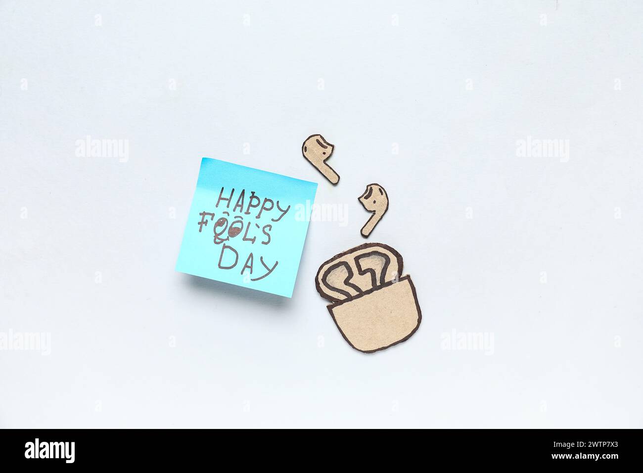 Sticky note and carton earphones on white background. April Fools Day ...