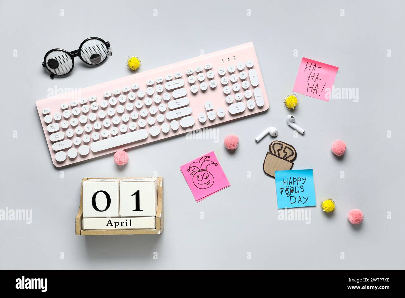 Carton earphones, sticky notes, computer keyboard and calendar on white ...