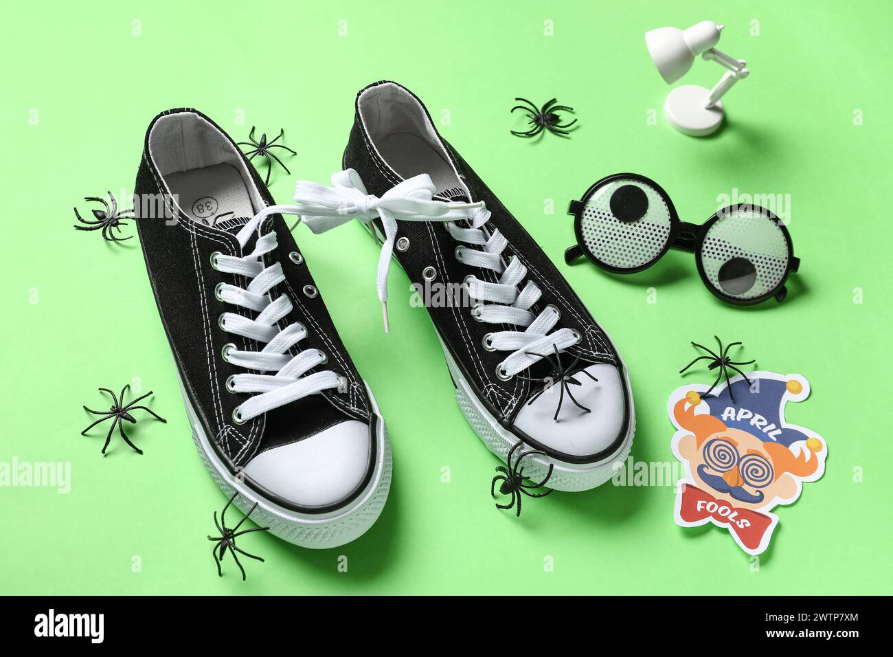 Shoes with tied together laces and funny glasses on green background ...