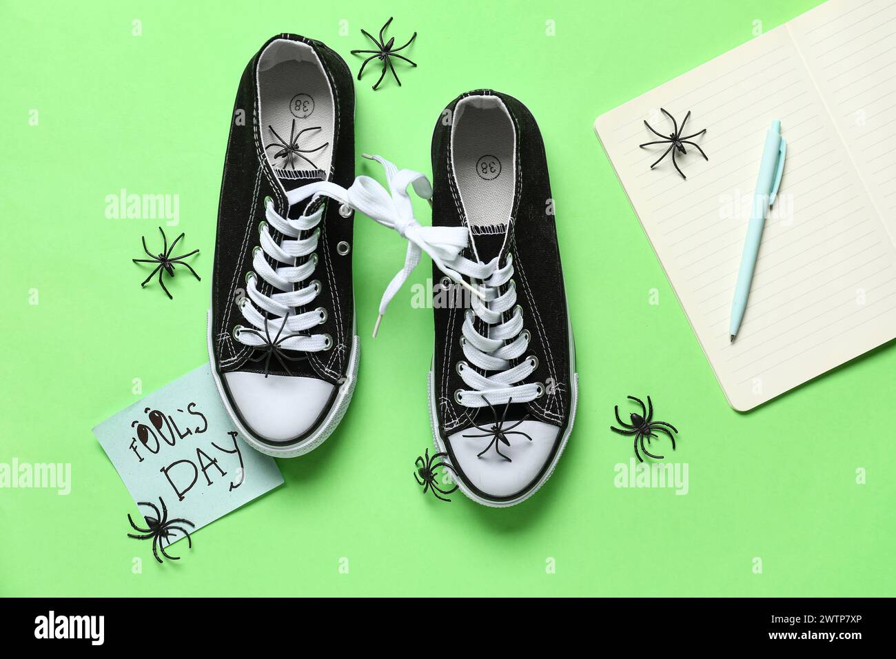 Shoes with tied together laces and sticky note on green background ...