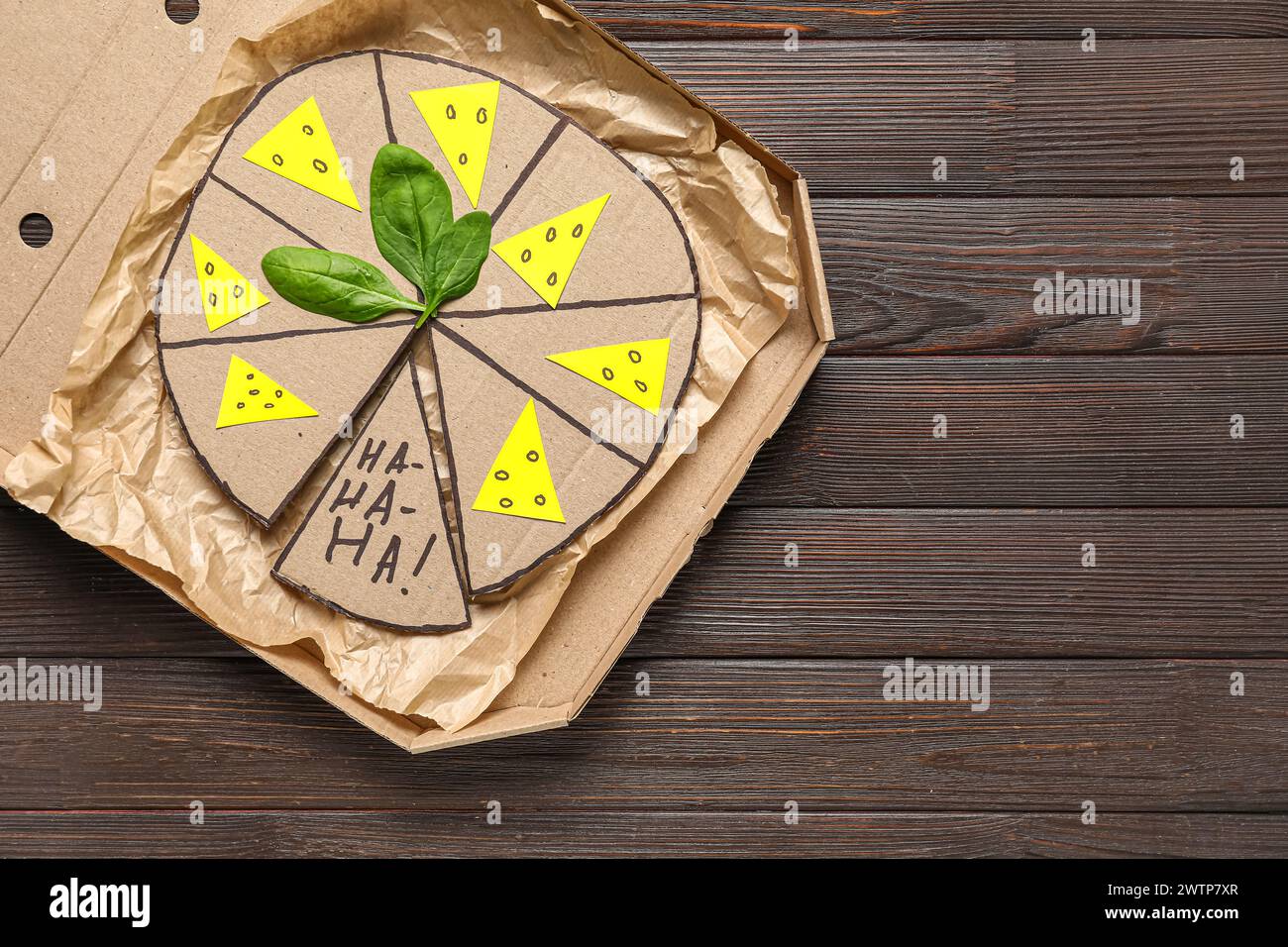 Carton pizza on wooden background. April Fools Day prank Stock Photo ...