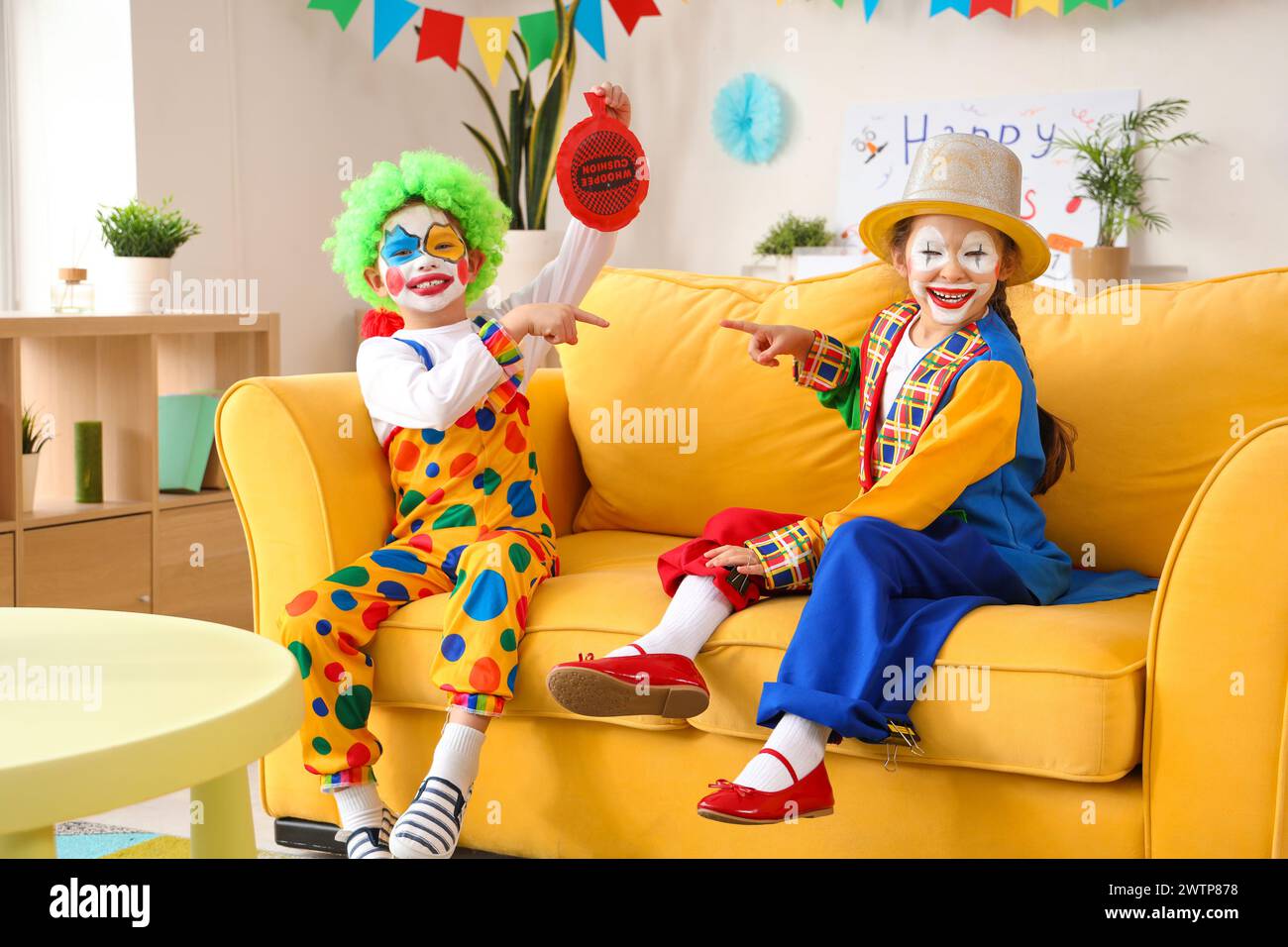 Funny little children in clown costumes at home. April Fools' Day ...