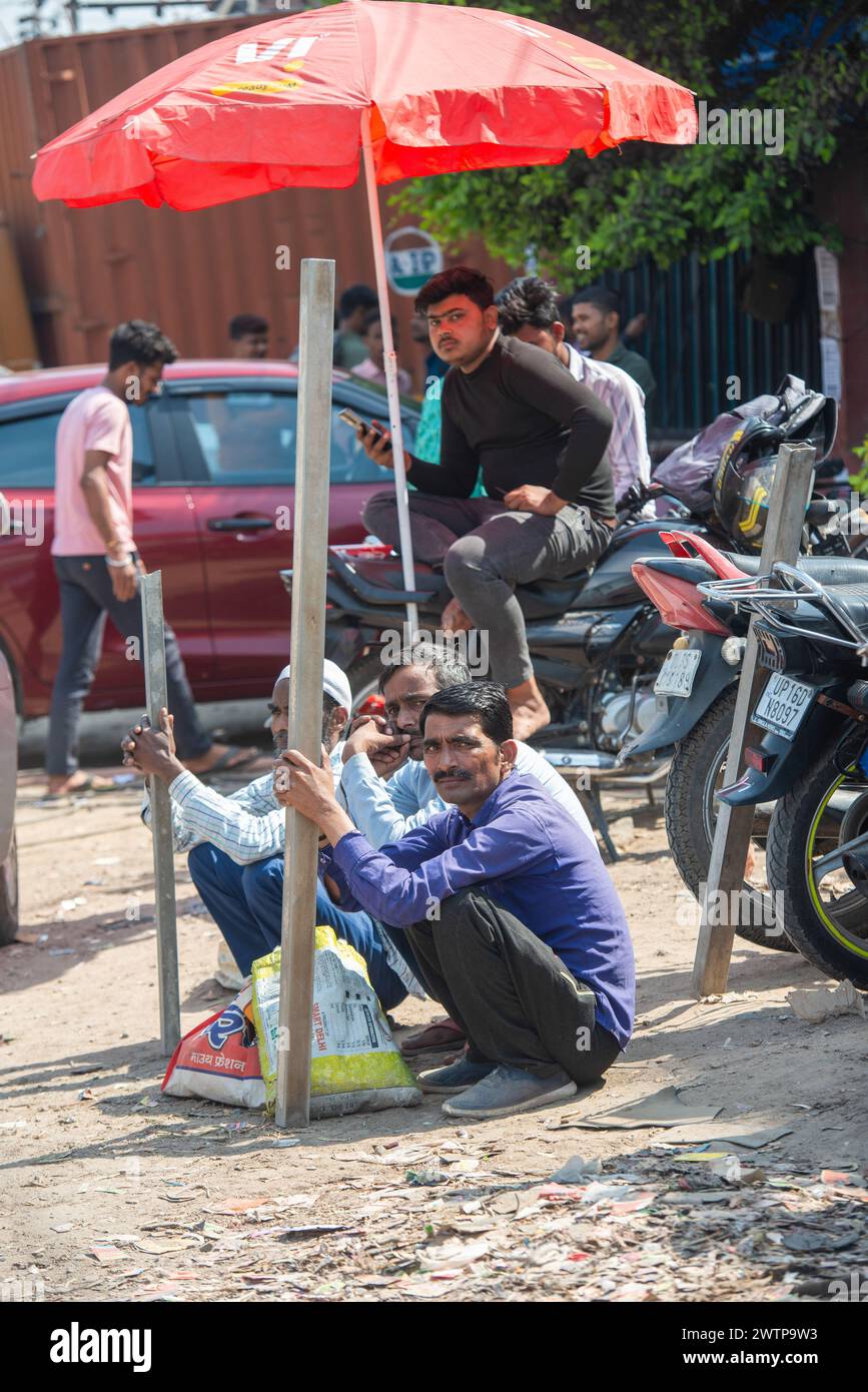 Gautam Buddh Nagar, India. 18th Mar, 2024. Daily wage workers wait for ...