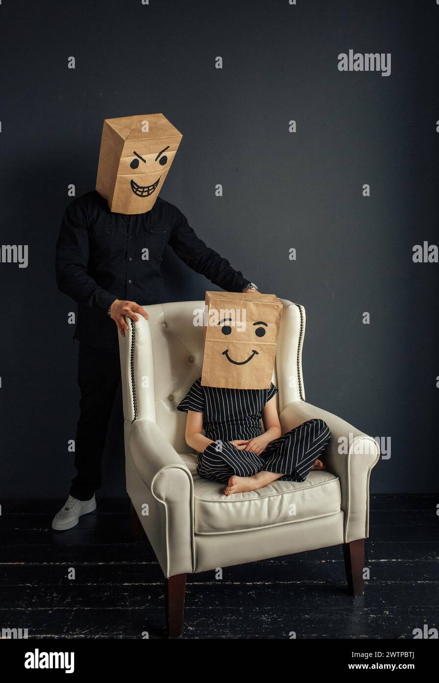 A person wearing a cardboard mask smiles standing beside another masked ...