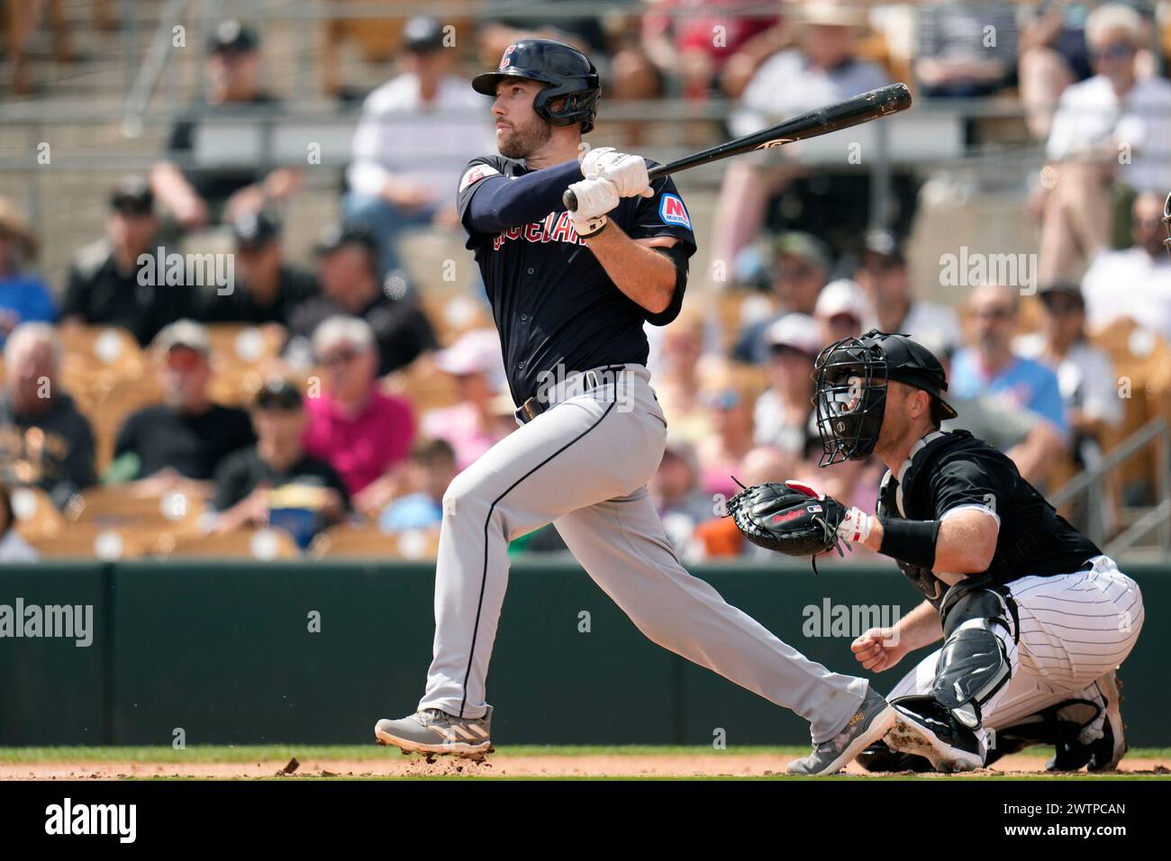 Cleveland Guardians' David Fry, left, follows through with his swing on ...