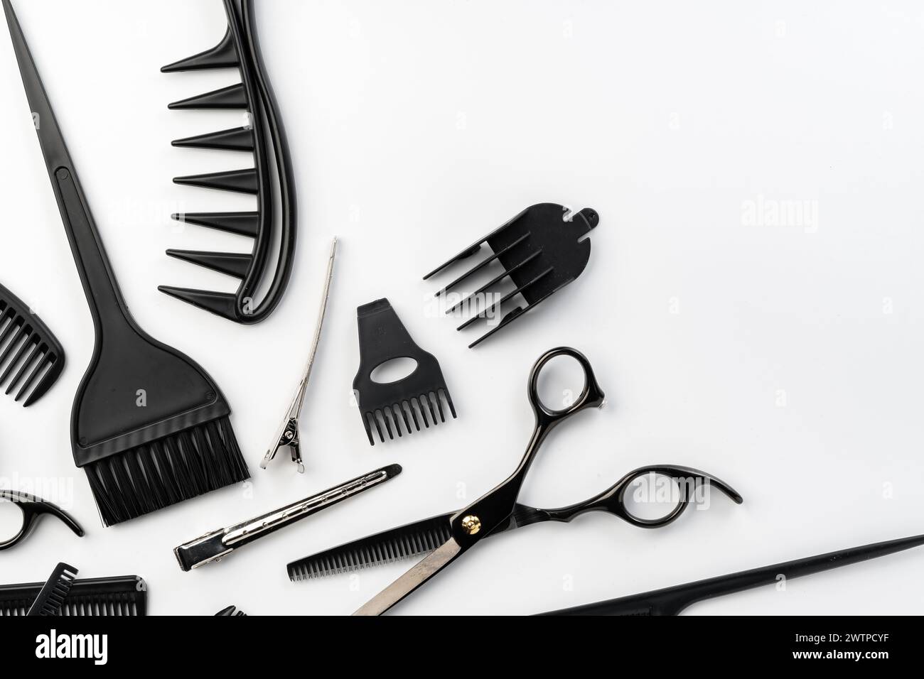 Black hairdressing tools and various hairbrushes on white background ...