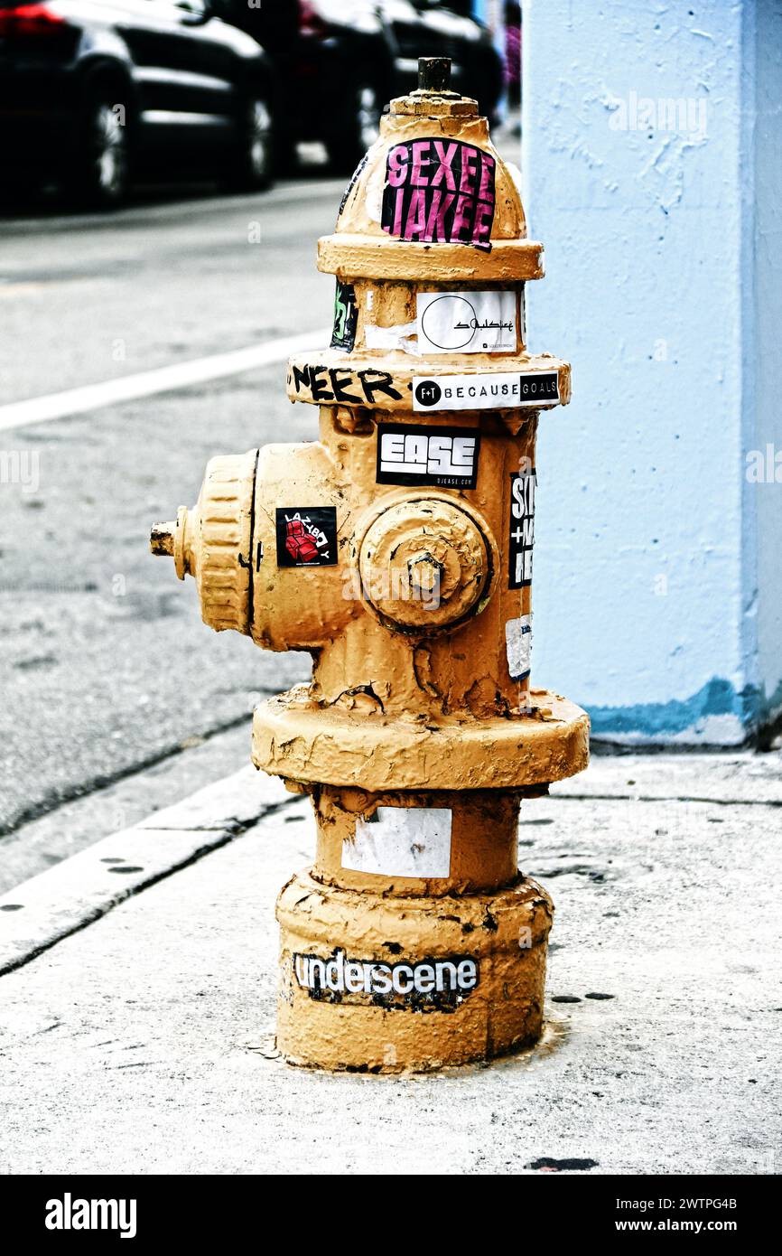 A yellow fire hydrant on a sidewalk next to the curb Stock Photo - Alamy