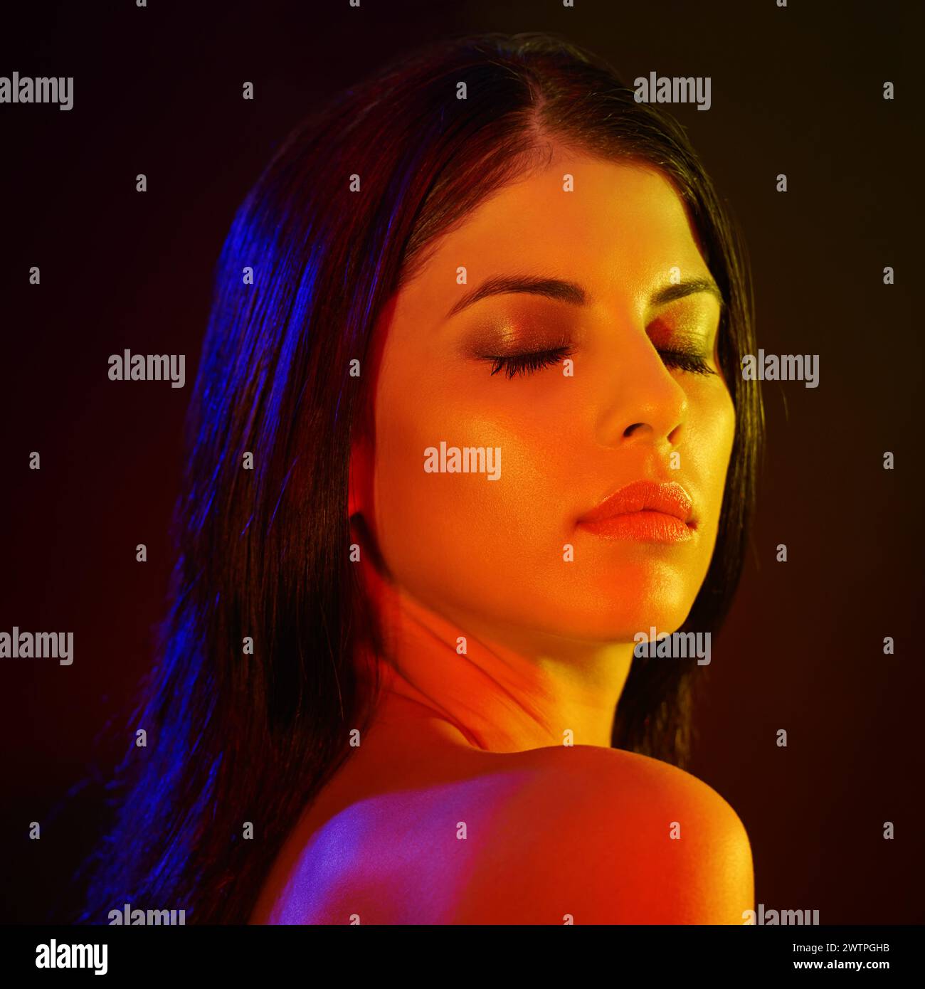 Studio, woman and beauty in color lighting with eyes closed, shadow and ...