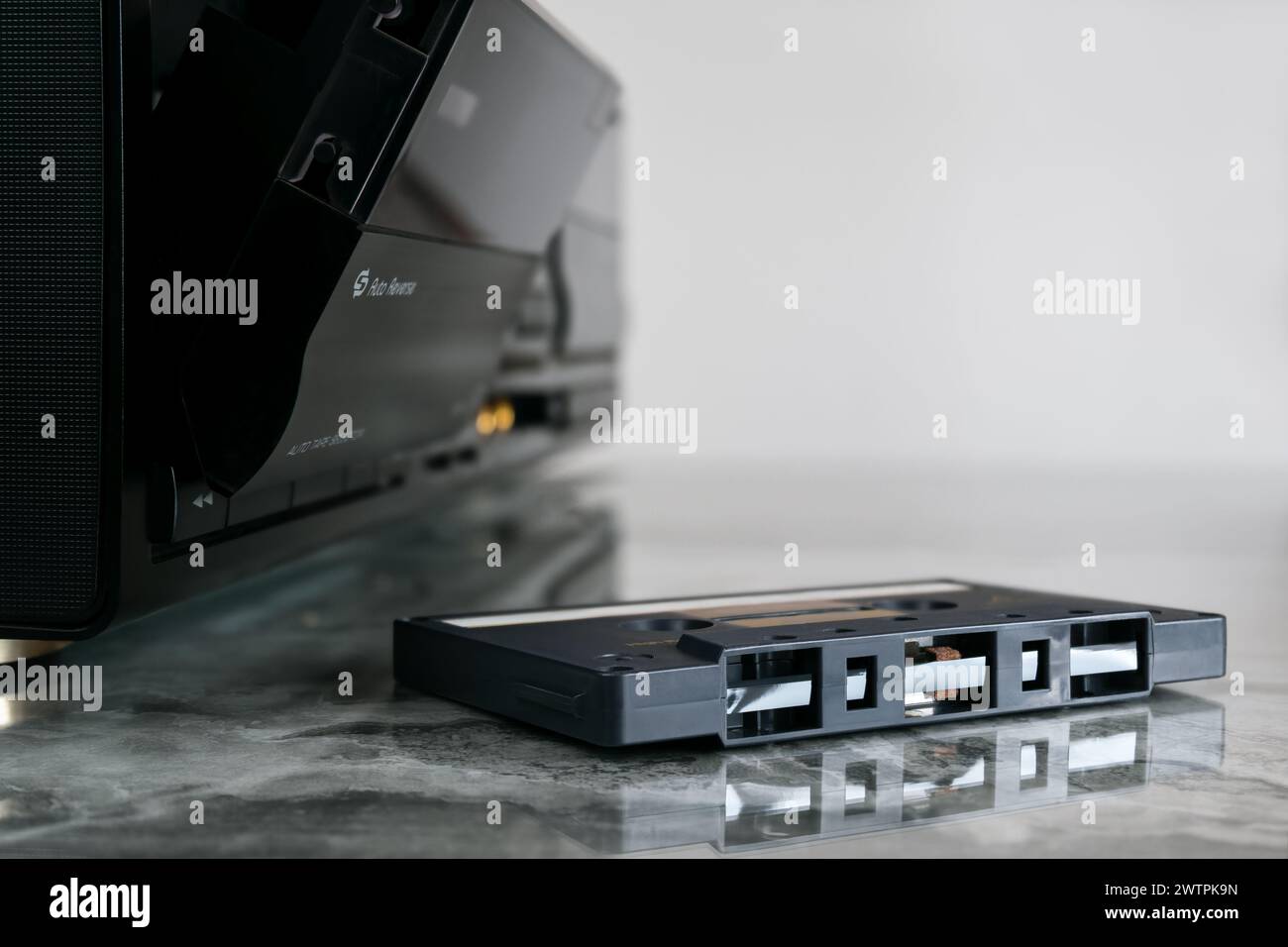 A cassette lies on a polished marble shelf next to an auto-reverse tape ...