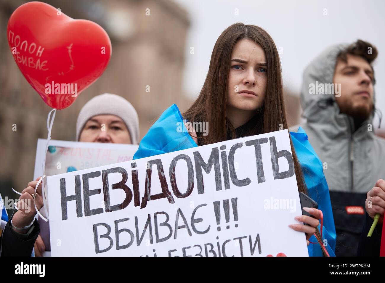Sad Ukrainian woman holds a banner "The Unknown Kills" on a ...