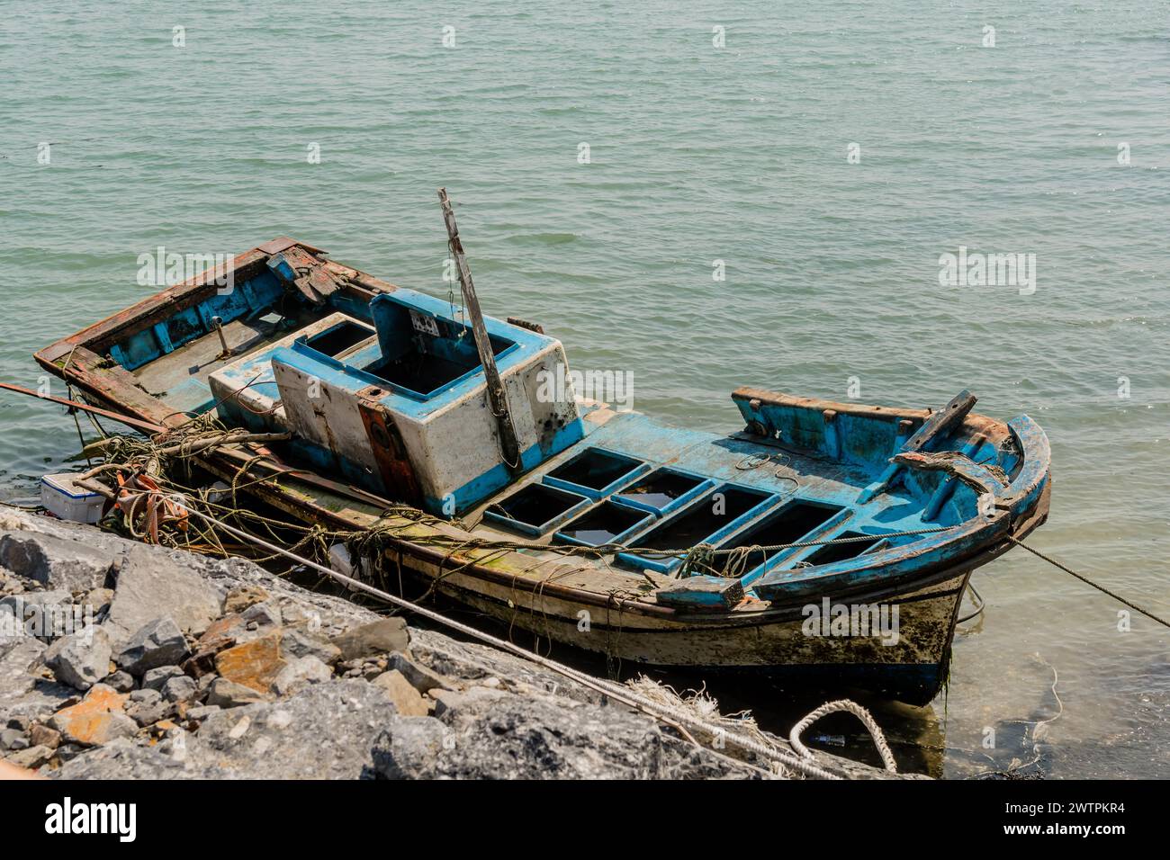 A rusty old boat abandoned by the sea, showing signs of decay, in ...