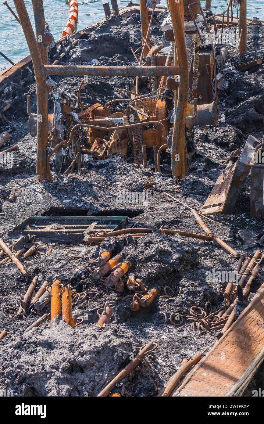 Blackened debris and mechanical parts from sunken ship wreckage in an ...