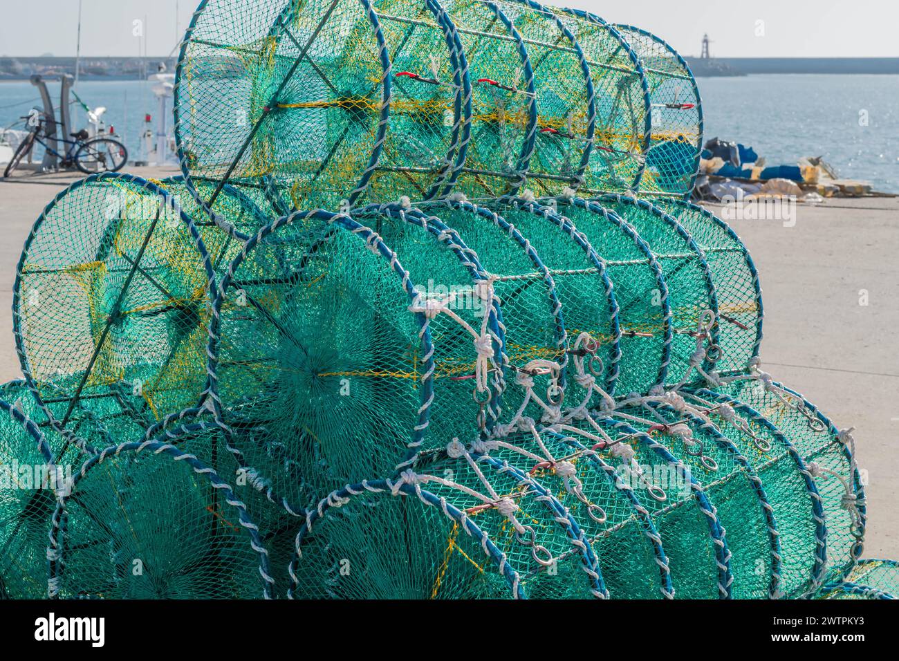 Piles of crab traps at a port with a sea view and lighthouse in the ...