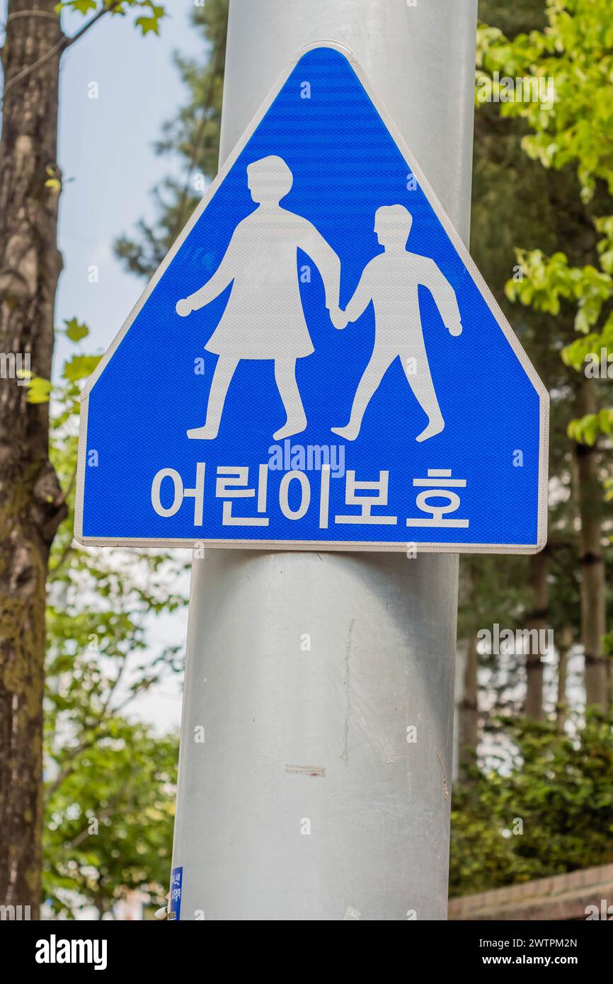 A blue pedestrian crossing sign featuring the silhouette of two ...