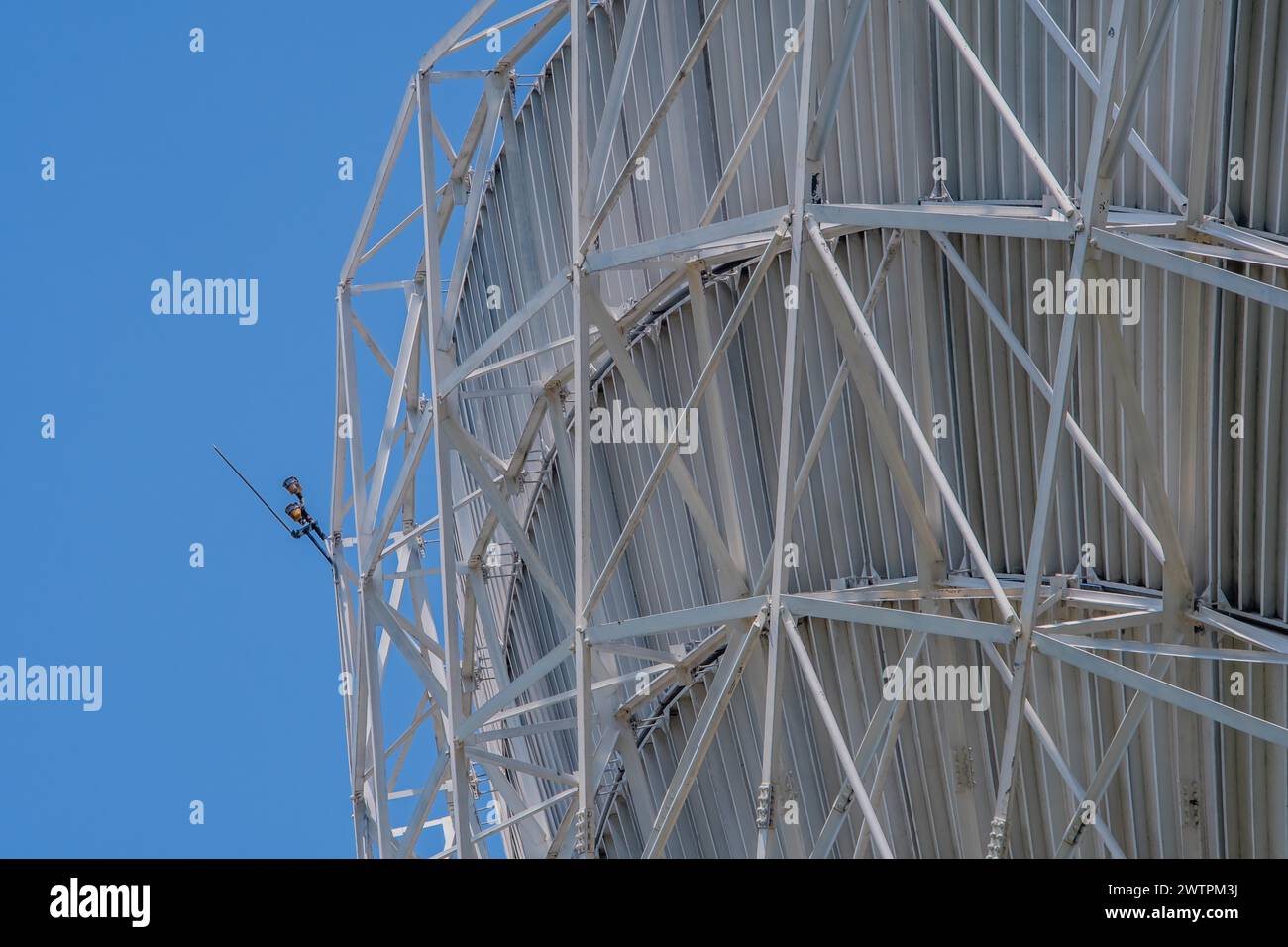 Workers on a towering metal structure emphasizing construction and ...
