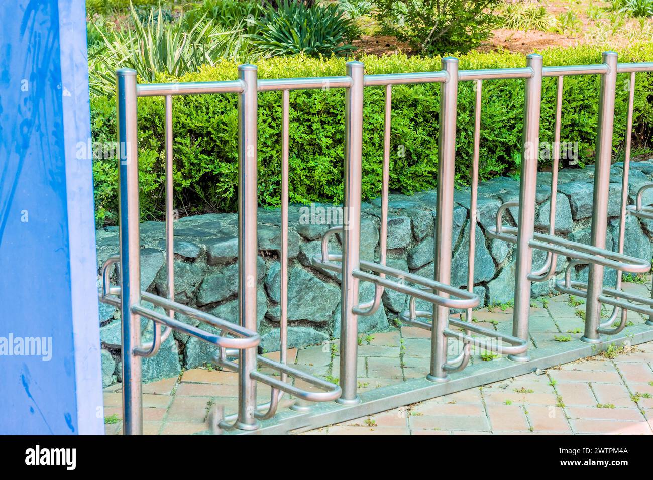 Empty metal bicycle rack in an urban park setting on a paved sidewalk ...
