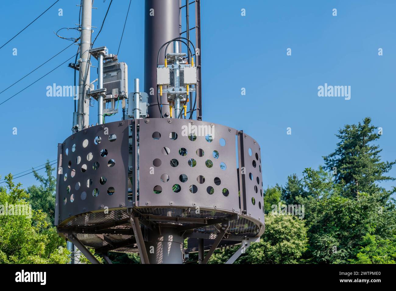 A metal cell tower equipped with various microwave antennas against a ...