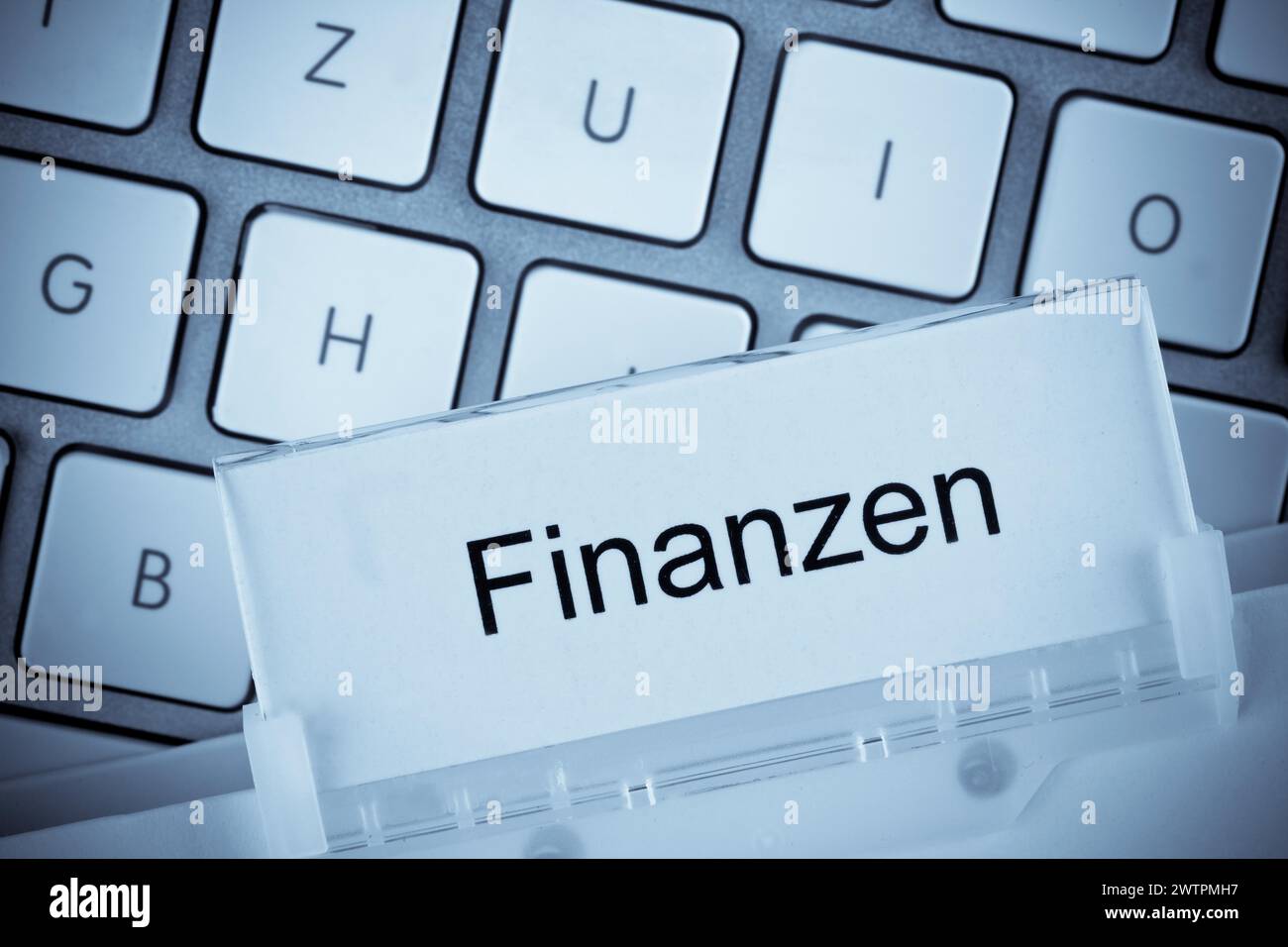 The folder of a hanging file in front of a computer keyboard on the ...