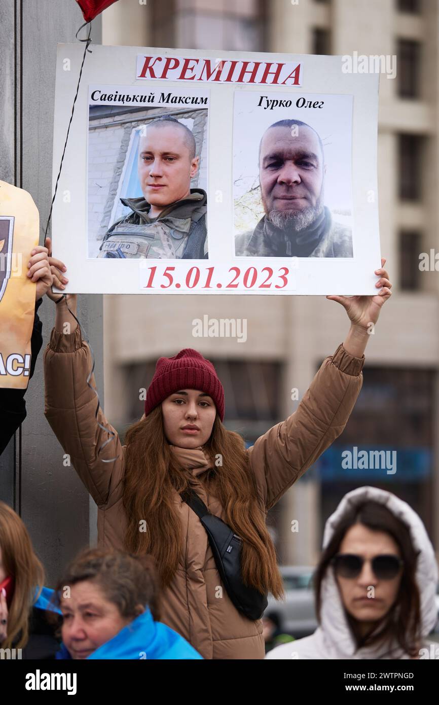 Young Ukrainian person posing with a banner with portraits of her ...