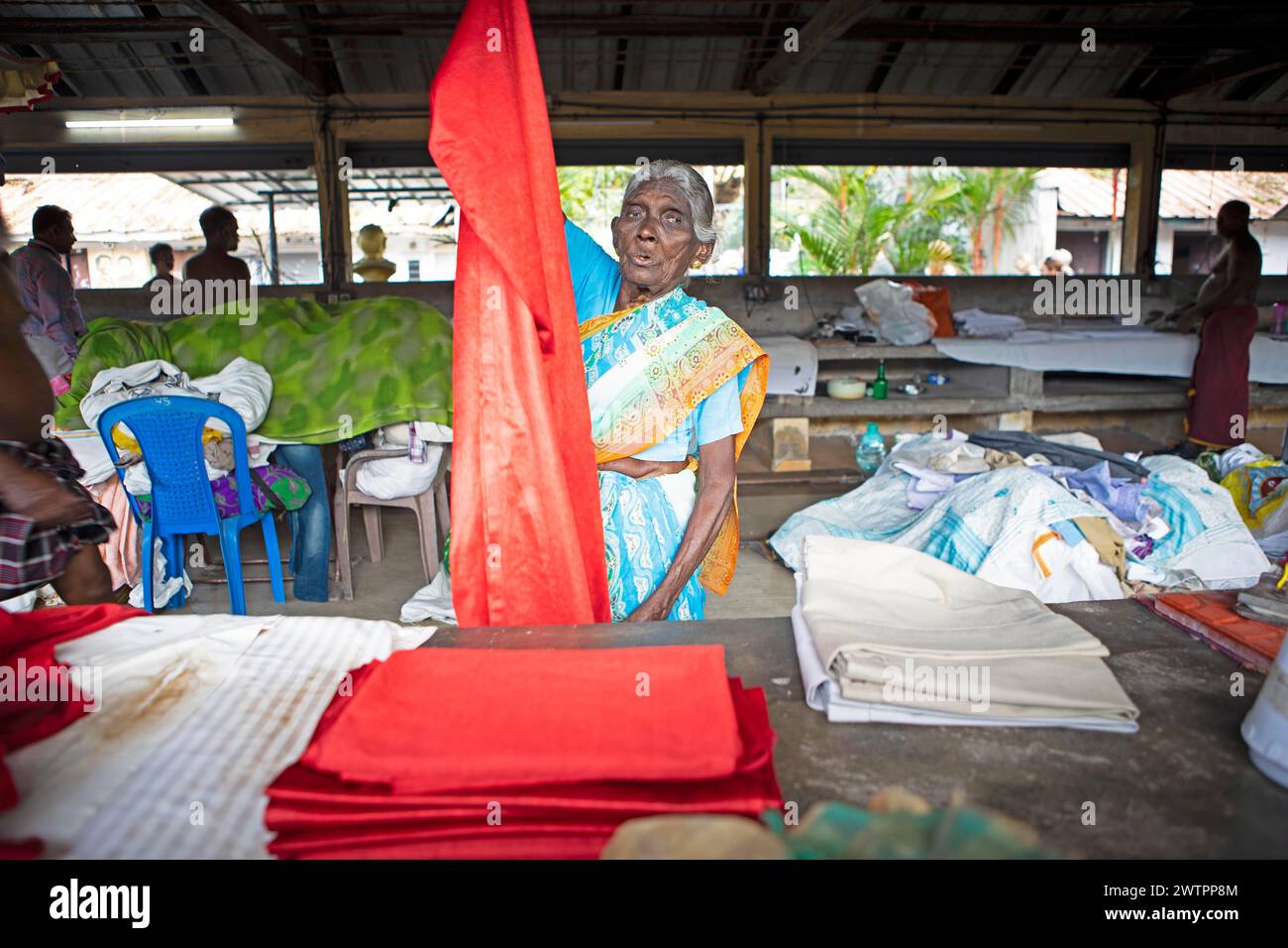 Indian woman folding laundry at Dhoby Khana laundry, Kochi, Kerala ...