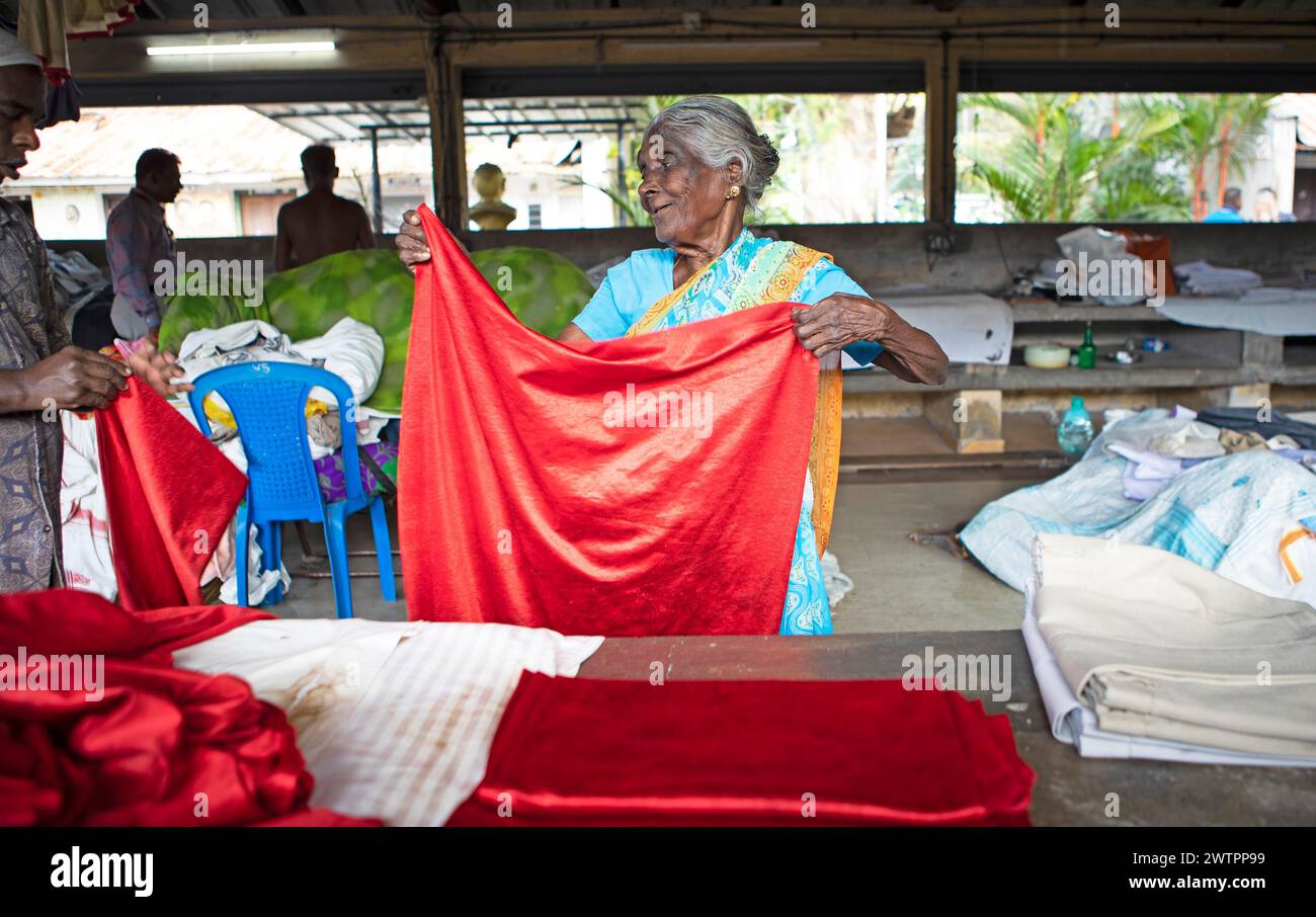 Indian woman folding laundry at Dhoby Khana laundry, Kochi, Kerala ...