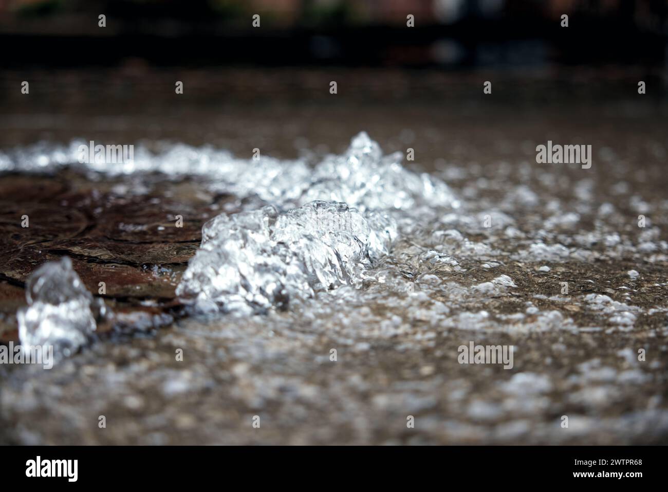 Water pipe burst, water Water flows out of the manhole onto the asphalt ...