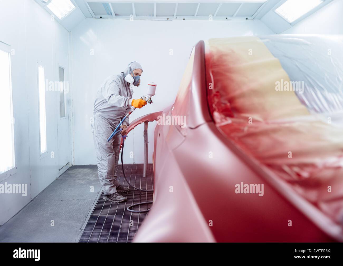 Male mechanic in Painting Booth spray a car in chamber. Car service ...