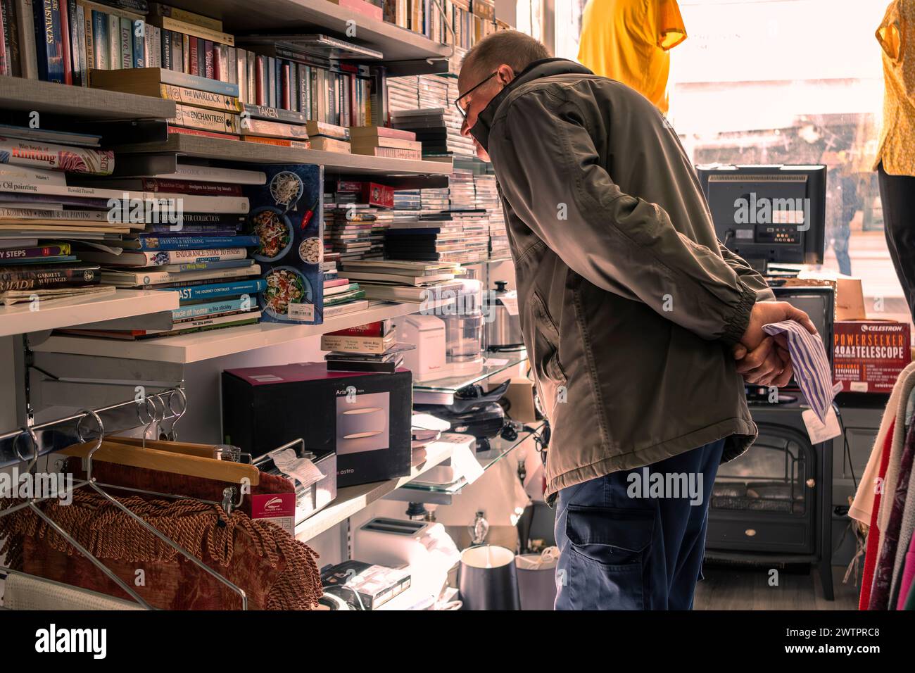 A customer browsing in a charity shop in the UK Stock Photo - Alamy