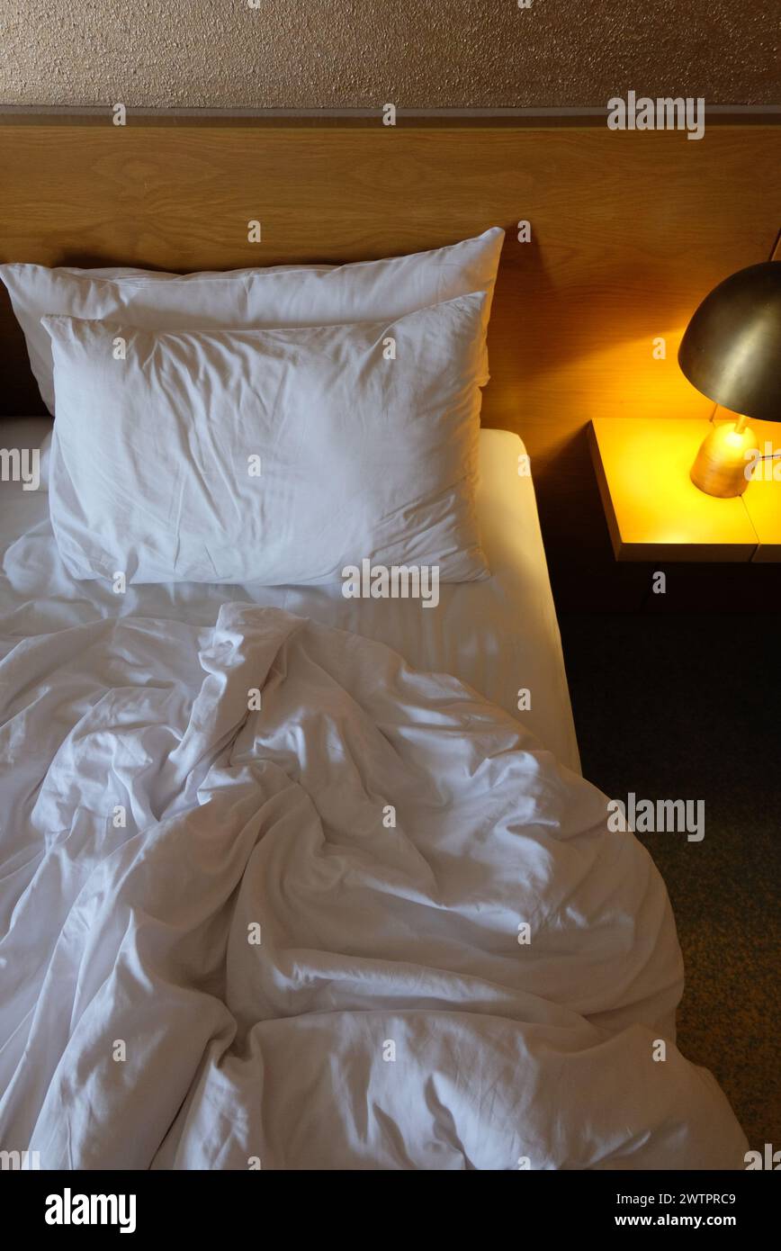 Selective focused of messy bedroom with lamp near bed. Wrinkled bed ...