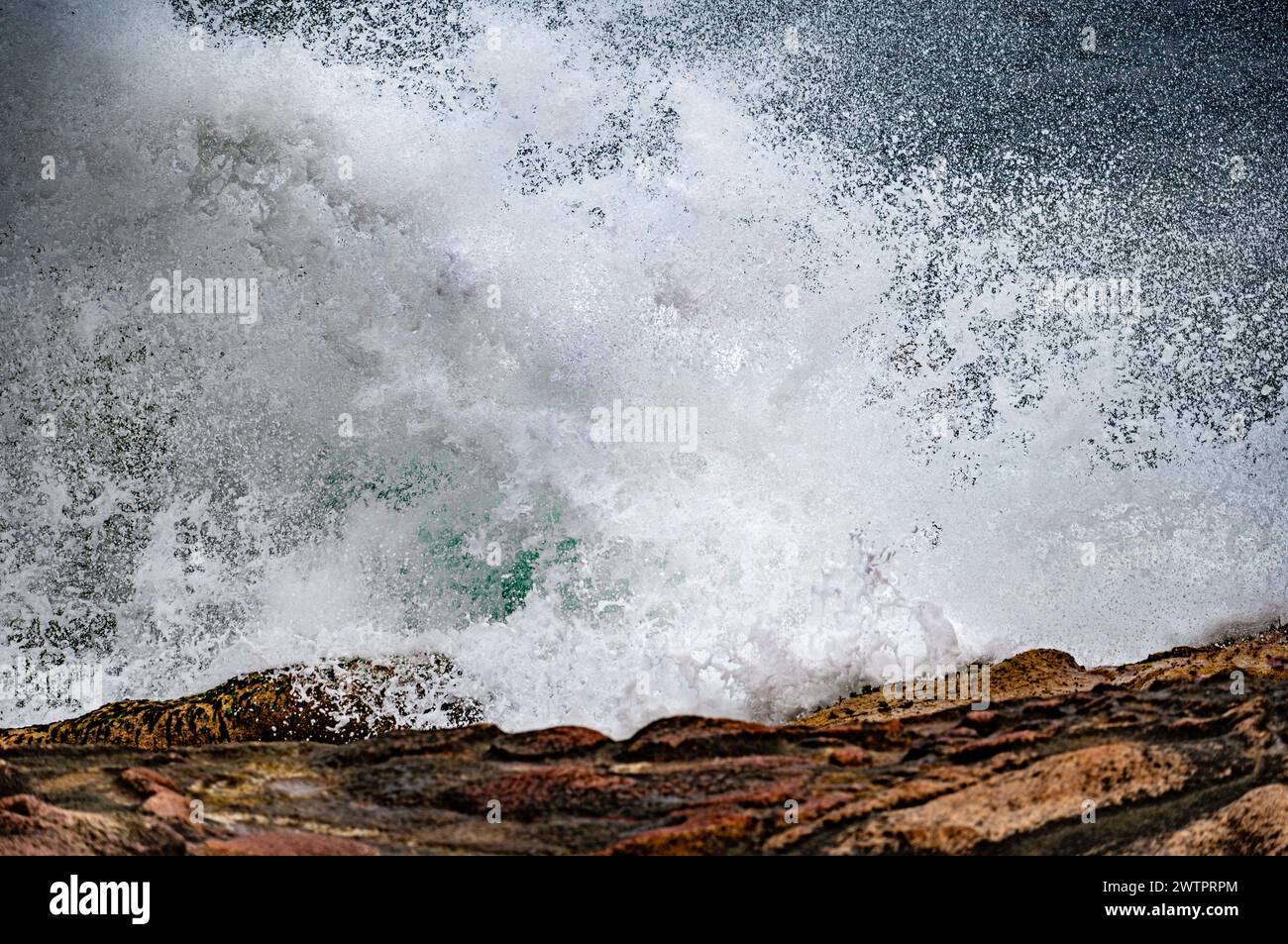 powerful waves relentlessly crash against rugged boulders and stones ...