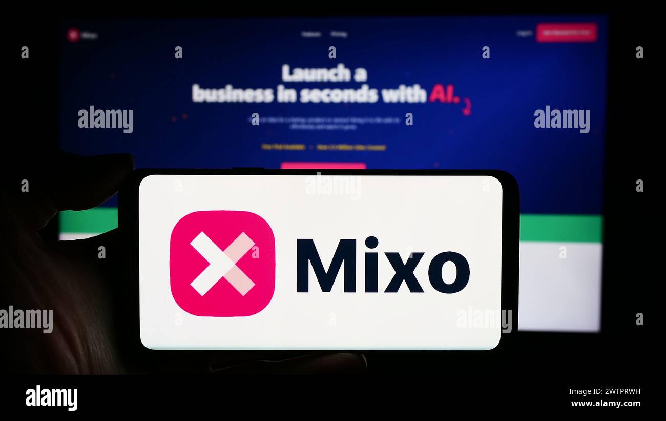 Person holding cellphone with logo of AI website building company Mixo ...