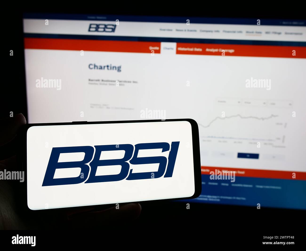 Person holding mobile phone with logo of consulting company Barrett Business Services Inc. (BBSI ...