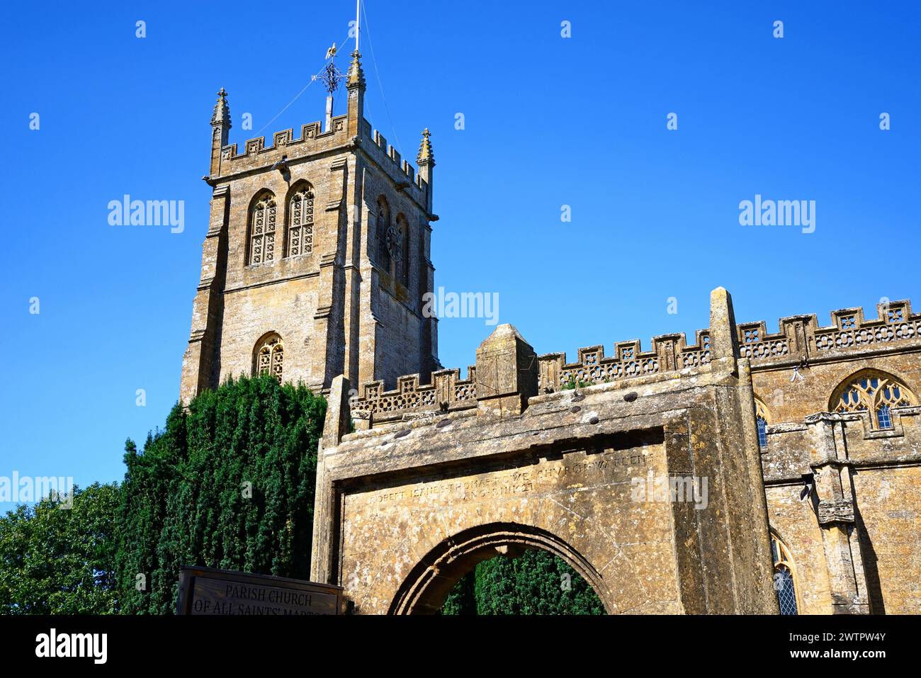 Entrance arch to All Saints church with the church to the rear along ...