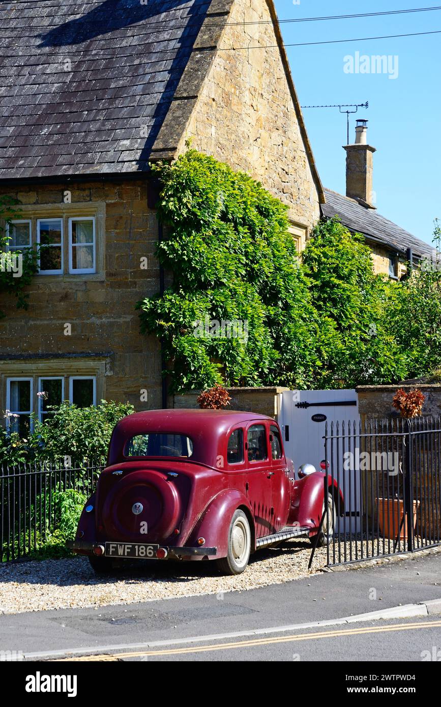 Old fashioned burgundy Rover car parked outside a house along Church ...