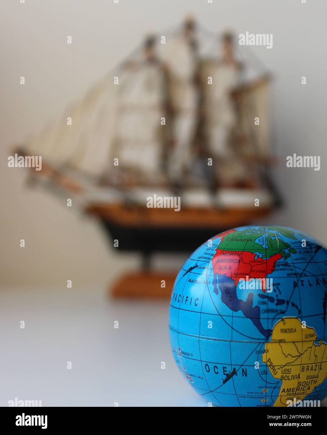 Small Globe With Mapped Travel Routes And Defocused Masted Ship Toy On ...