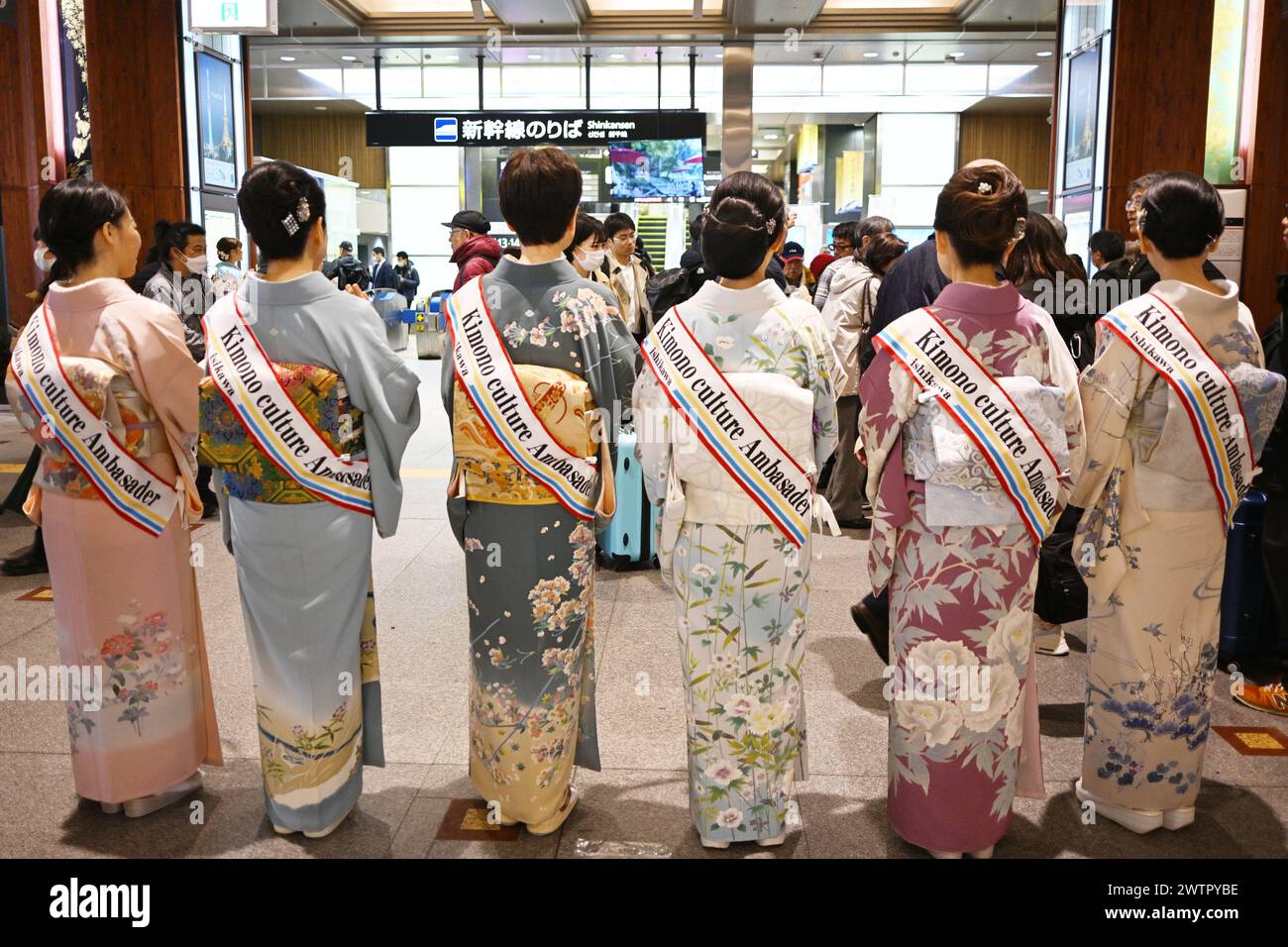 Japanese women wearing kimonos welcome passengers at Kanazawa Station ...