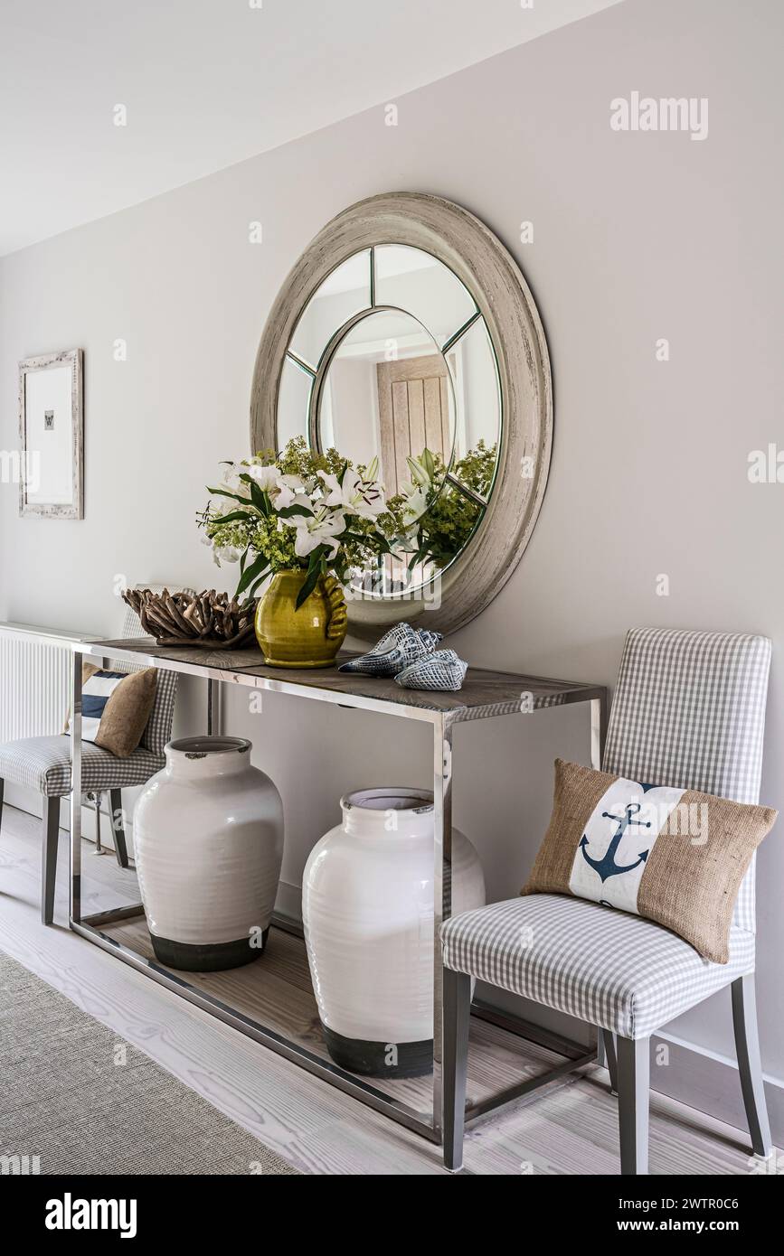Large circular mirror above console in hallway of British home in ...