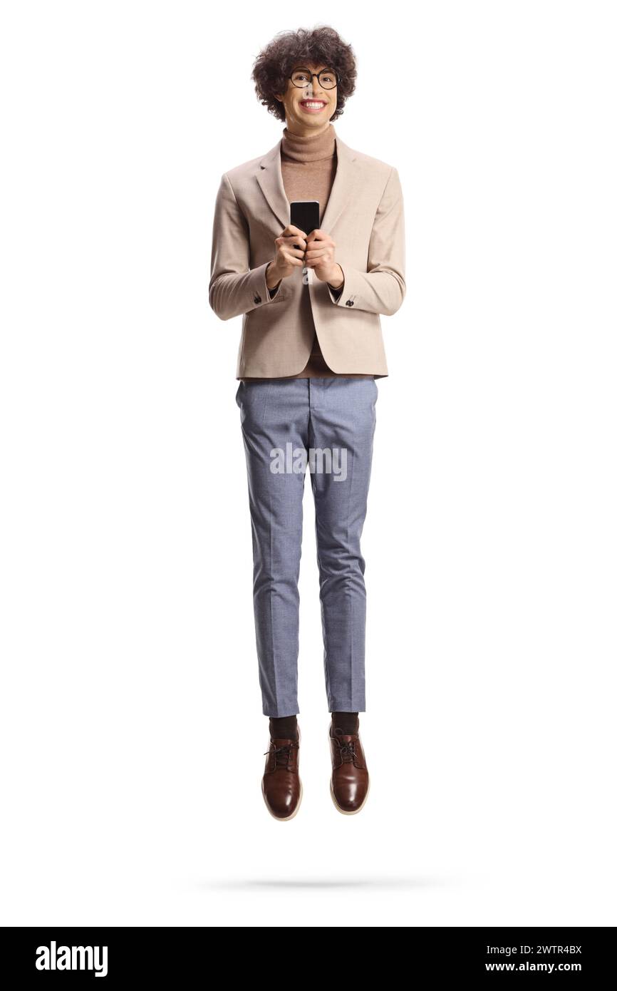 Hppy tall guy with glasses using a smartphone and jumping isolated on ...
